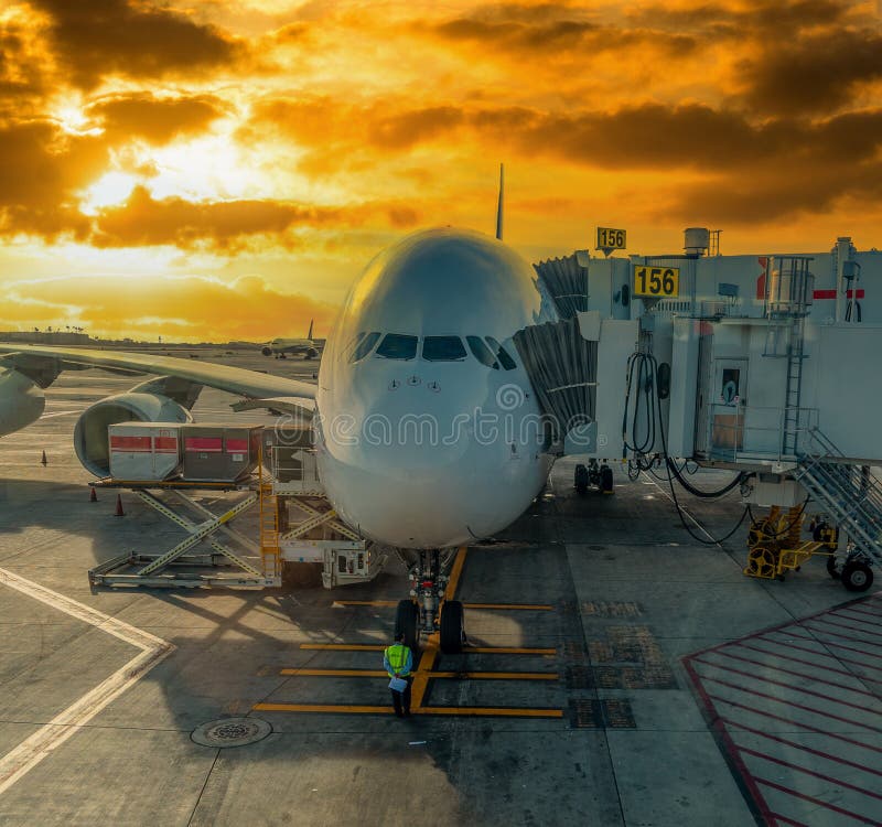 Aircraft Linked To an Aerobridge Under an Orange Sky Stock Image ...