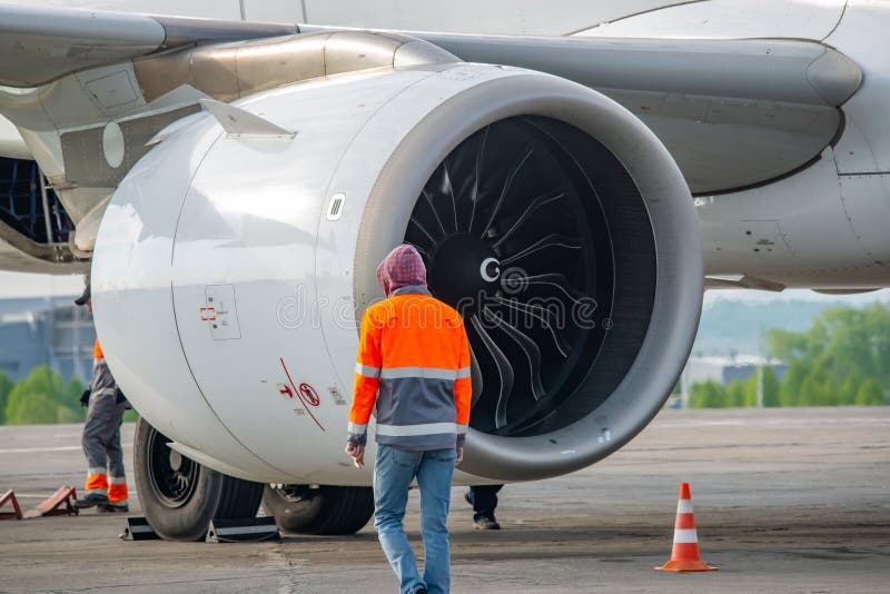 Aircraft Maintenance Worker Checking the Engine of a Commercial ...