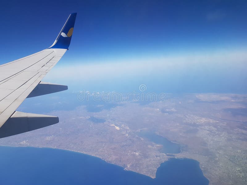 Aircraft Wing Outside Plane Window on Blue Sky Background, Closeup ...