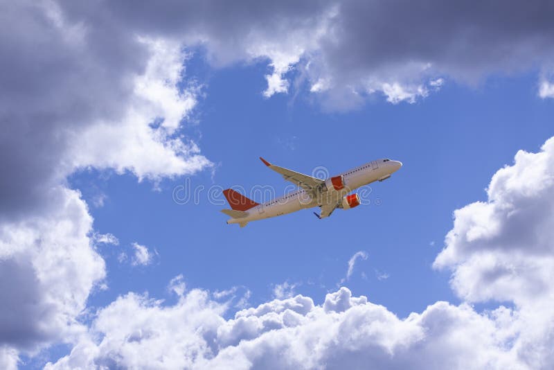 An Airline Plane Flying in a Blue Sky Inside Big White Clouds. Image ...