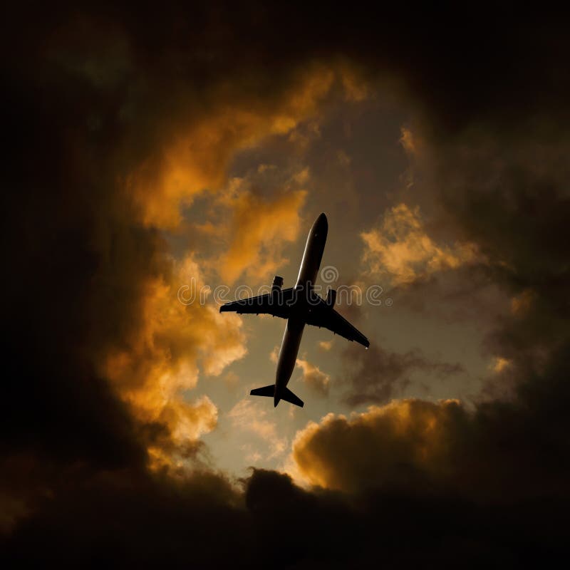Airplane Flies through Orange Dramatic Clouds Stock Photo - Image of ...