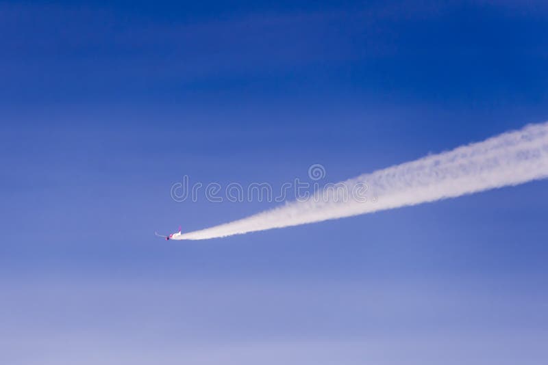 An Airplane in Flight Leaves a Long White Trail of Smoke Behind Itself ...