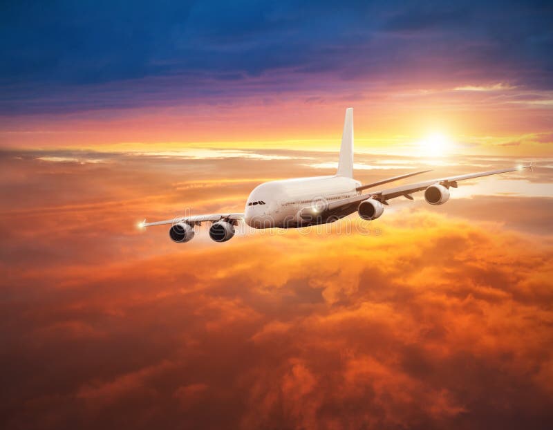 Airplane Flying Above Clouds in Dramatic Sunset Stock Photo - Image of ...