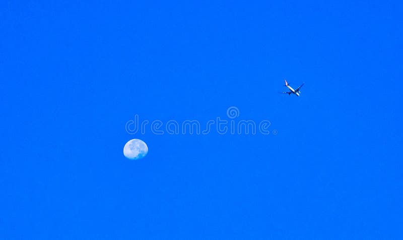 Airplane Flying Across the Full Moon in the Blue Sky during Magic Hour ...