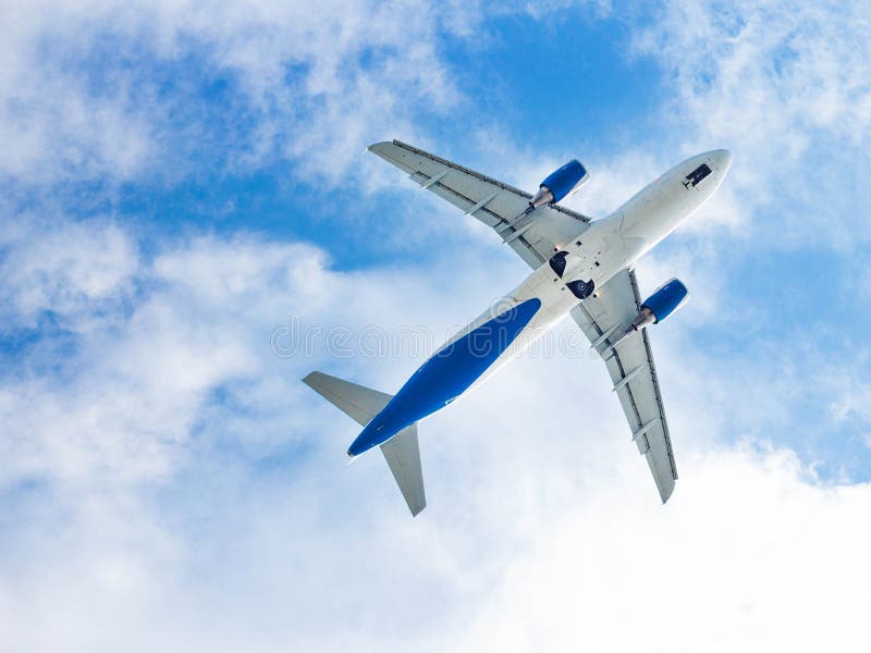 Airplane Flying in the Cloudy Blue Sky, Bottom View Stock Photo - Image ...
