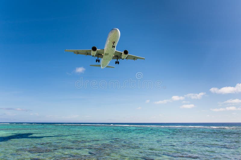 Airplane Flying Over the Beach Under a Blue Sky Stock Image - Image of ...