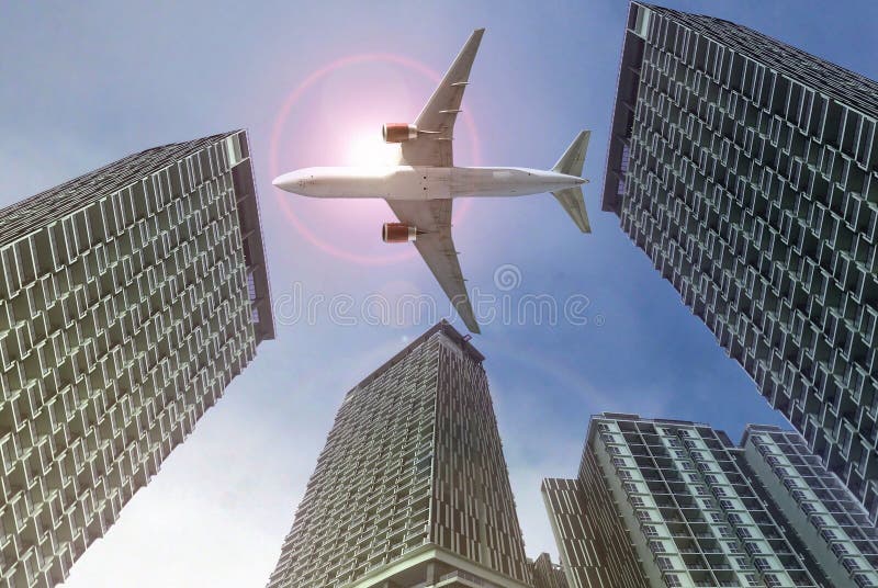 Airplane Flying Over High Rise Buildings with Bright Sunlight in ...