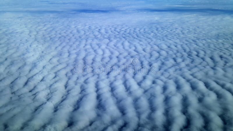 Airplane Gliding Over a Sea of Wavy Clouds Beneath a Clear Blue Sky ...