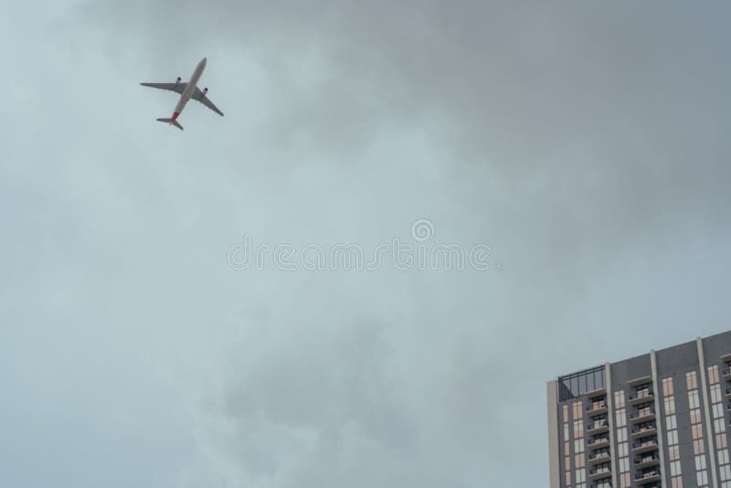 Airplane on a Grey Sky with a Building in the Corner Stock Image ...
