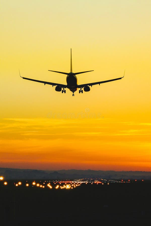 Airplane Landing on the Runway during Sunset and Dusk Stock Photo ...