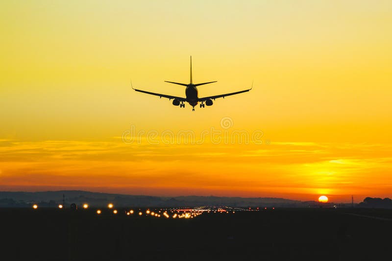 Airplane Landing on the Runway during Sunset and Dusk Stock Photo ...