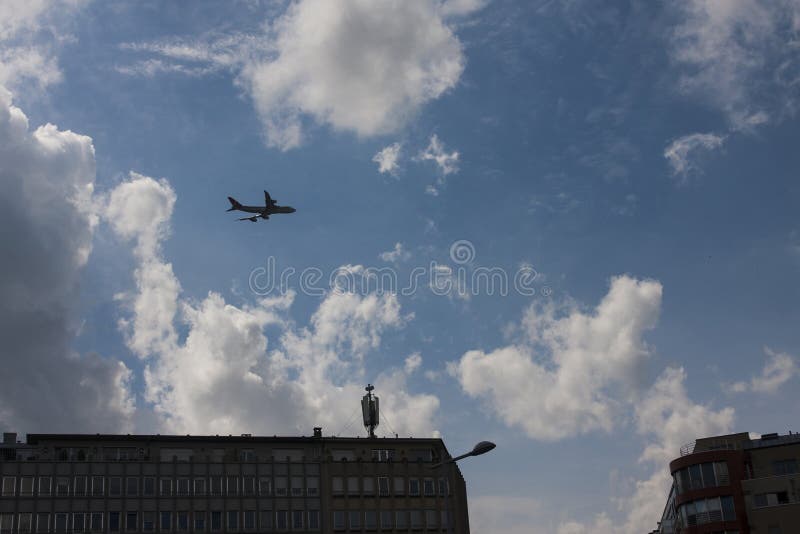 Airplane over buildings stock photo. Image of flight - 96294126