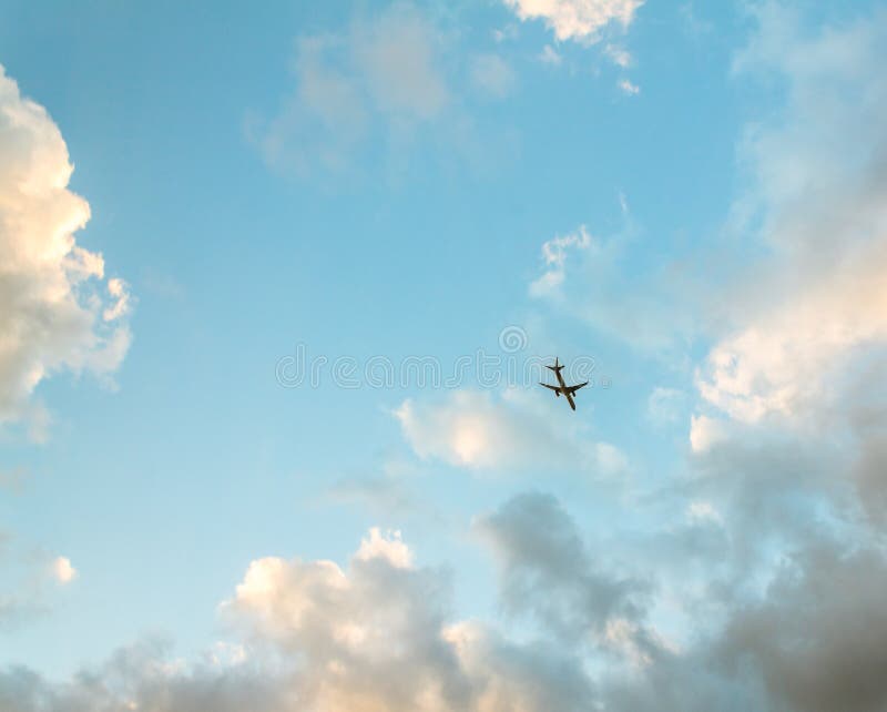Ground View of an Airplane Against Thick Clouds and Blue Sky Looking Up ...