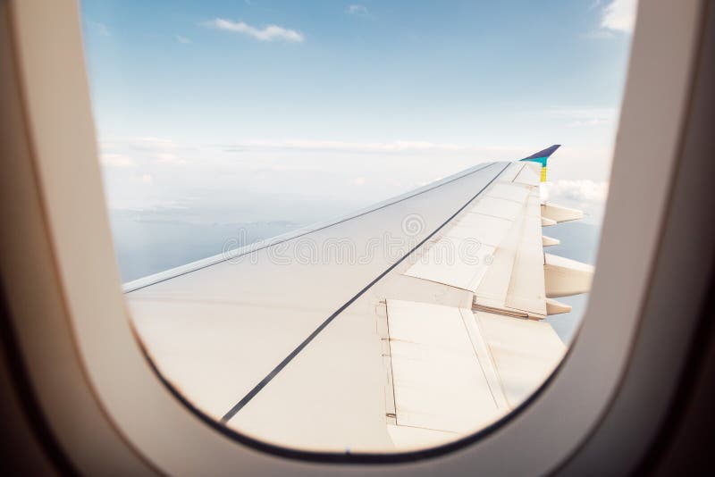 Airplane Wing and Blue Sky through the Aircraft Window Stock Image ...