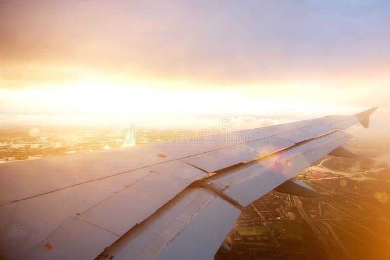 Airplane Wing Descending through the Clouds at Sunset Stock Image ...