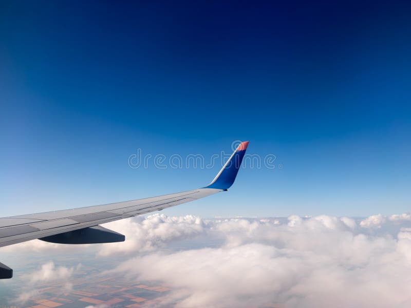 Airplane Wing Over Cloudy Landscape Under Clear Blue Sky at High ...