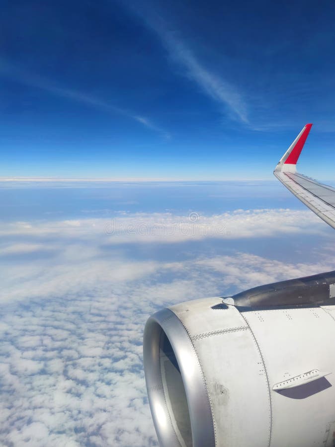 Airplane Wing through the Window Aircraft during Flight with a Blue Sky ...