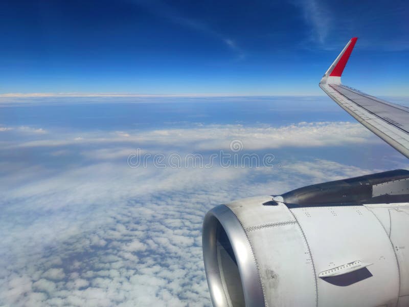 Airplane Wing through the Window Aircraft during Flight with a Blue Sky ...
