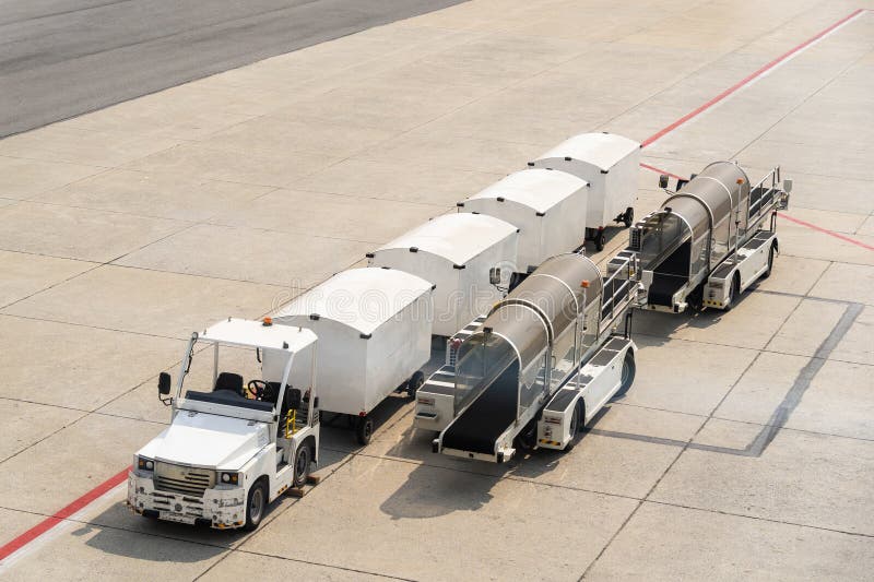 This is an Airport Baggage and Cargo Tractor Pulling a Train of Luggage ...
