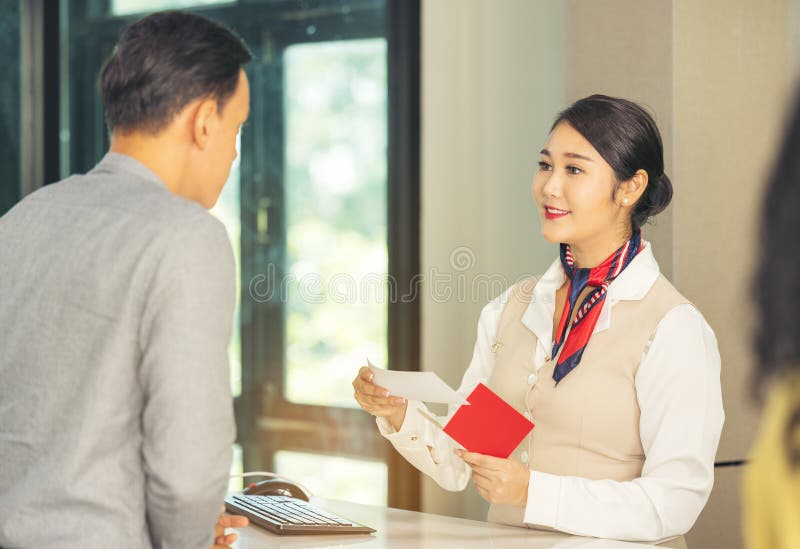 At the Airport Check-in Counter, a Passenger Hands Over His Documents ...