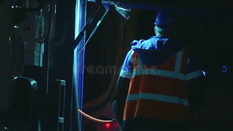Airport Worker Guiding a Plane with Illuminated Wands on a Rainy Night ...