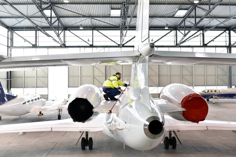 Airport Workers Check an Aircraft for Safety in a Hangar Stock Photo ...