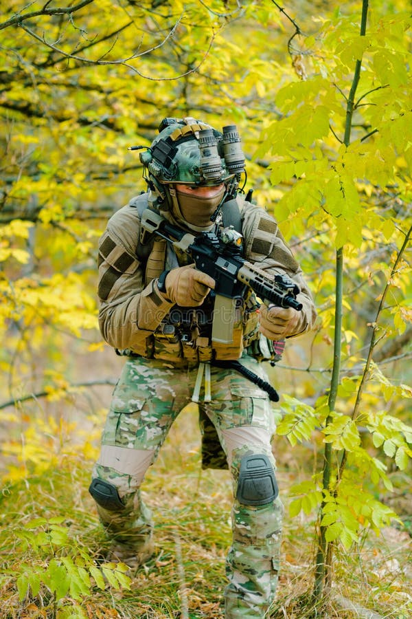 Airsoft Man in Uniform, Move with Machine Gun on Yellow Forest Backdrop ...