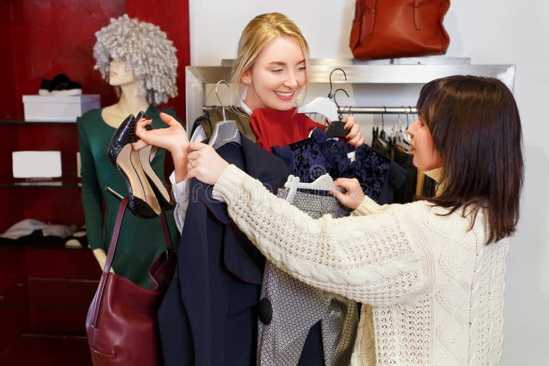 A Ajuda Do Assistente De Loja Escolhe a Roupa Imagem de Stock - Imagem ...