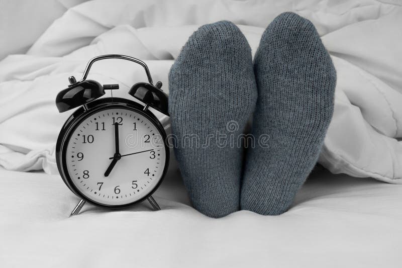 Alarm Clock on Bed Next To Female Feet in Socks Stock Image - Image of ...