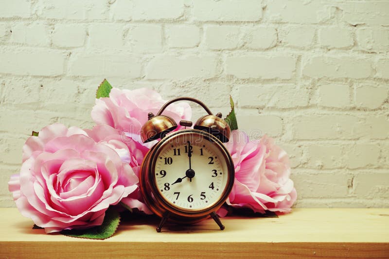 Alarm Clock with Flower Decorative on White Brick Wall Background Stock ...