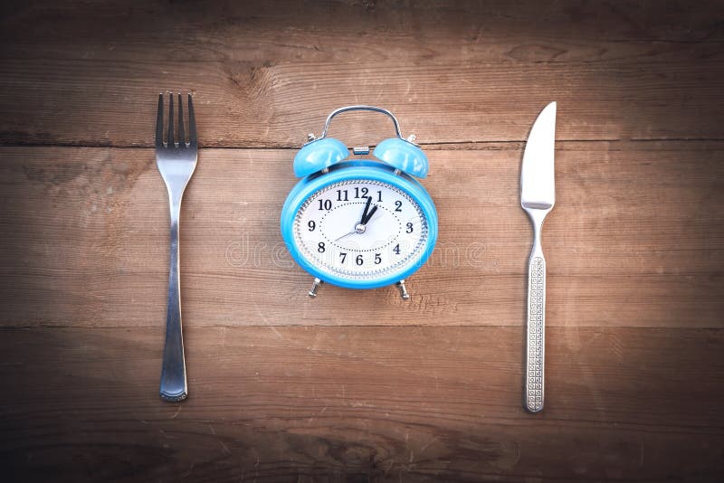 Alarm Clock with Fork and Knife on the Table. Time To Eat Stock Photo ...
