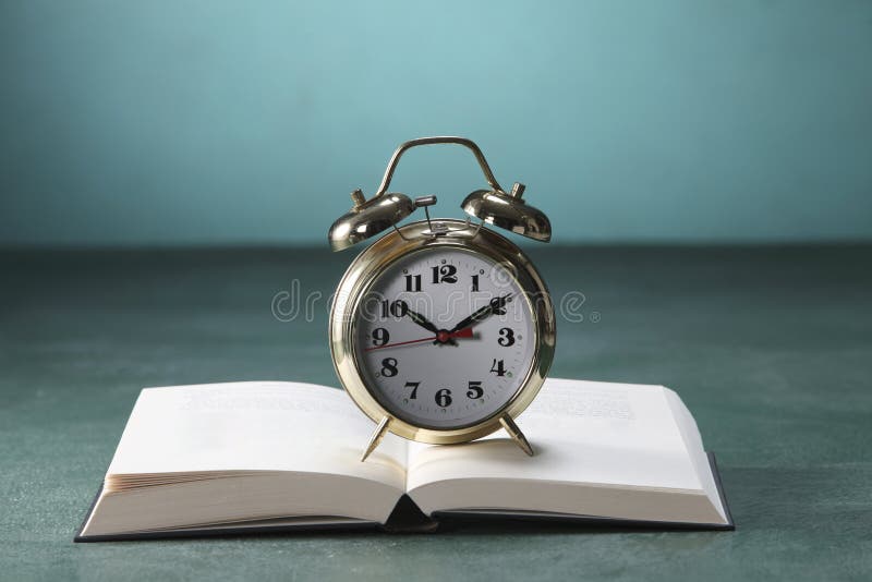 Alarm clock on open book stock photo. Image of page, color - 25816368