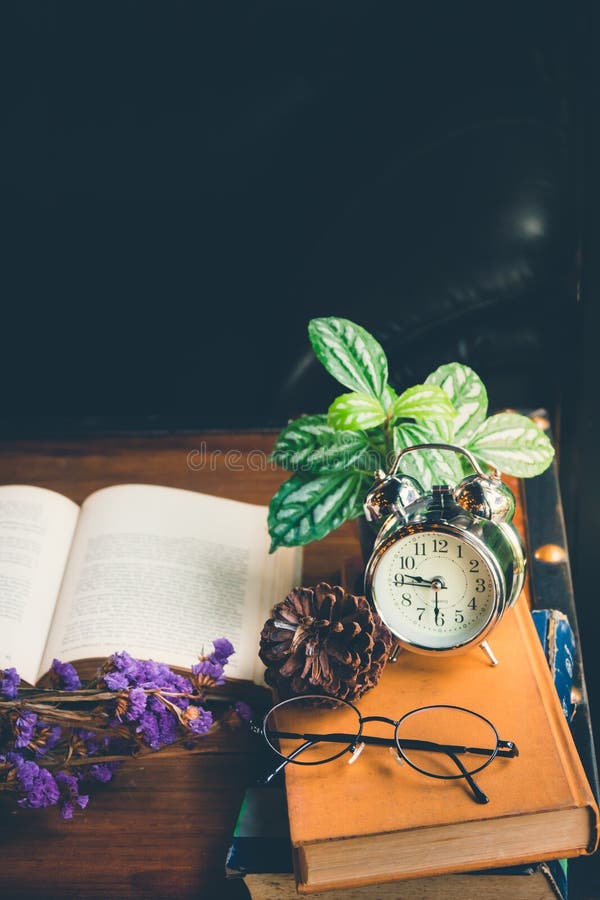 Alarm Clock with Open Book and Reading Glasses on Table in Cafe. Stock ...