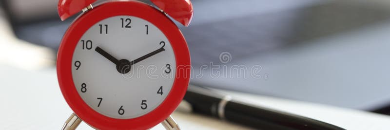 Alarm Clock with Pen on Blank Page with Blurry Laptop in Background ...
