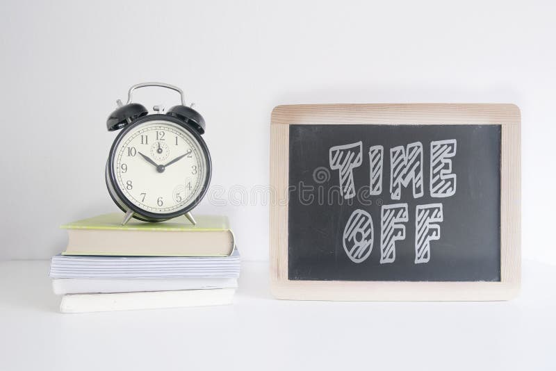 Alarm Clock on a Pile of Books Next To a Blackboard with the Text TIME ...
