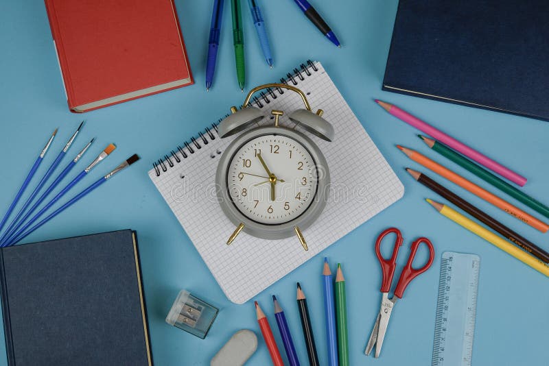 An Alarm Clock is on a Notebook with School Supplies Around it Stock ...