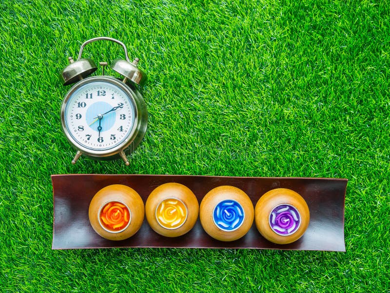 Alarm Clock and Scented Candles on Green Lawn. Stock Photo - Image of ...