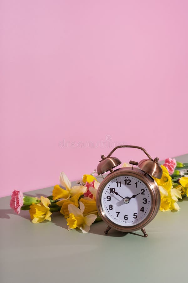 Alarm Clock with Spring Flowers. Spring Time, Daylight Savings Concept ...