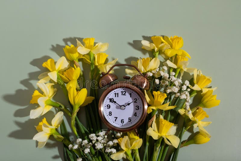 Alarm Clock with Spring Flowers. Spring Time, Daylight Savings Concept ...