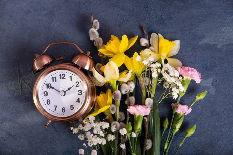 Alarm Clock with Spring Flowers. Spring Time, Daylight Savings Concept ...
