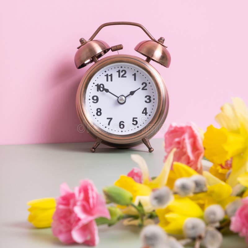 Alarm Clock with Spring Flowers. Spring Time, Daylight Savings Concept ...