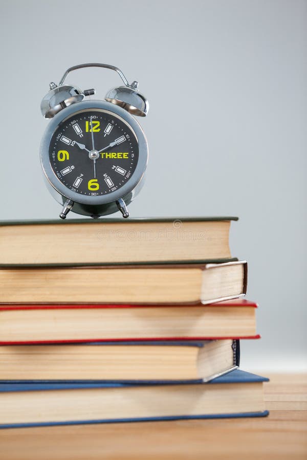 Alarm Clock and Stack of Books Stock Photo - Image of bell, information ...