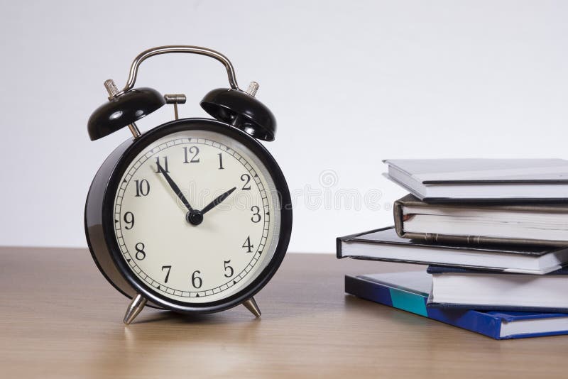 Alarm Clock Standing by Stack of Books Stock Photo - Image of bench ...