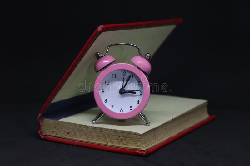 Alarm clock in a book. stock image. Image of night, morning - 159503857