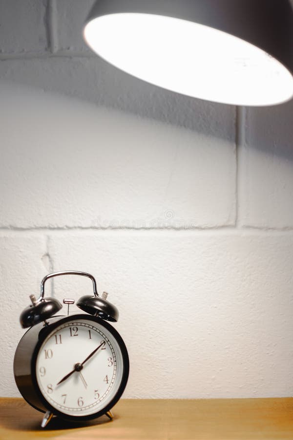 Alarm Clock on Table with Lamp and Blurred White Brick Stock Photo ...