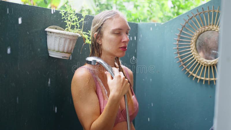 Woman Stands In An Open Shower Outside In The Rain Slow Motion Stock