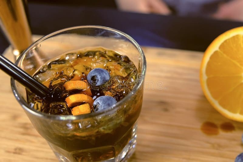 Alcohol Cocktail on the Rocks Glass with Orange, Ice and Blueberry on ...