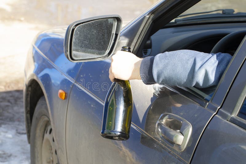 Alcohol while Driving a Car. a Driver Who Drinks Alcohol at the Wheel ...