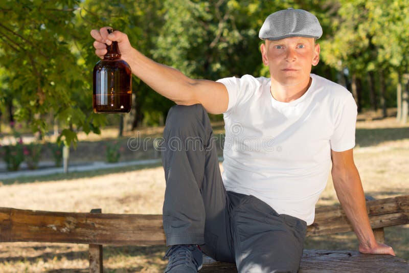 Alcoholic Sitting Alone in the Park with a Bottle Stock Photo - Image ...