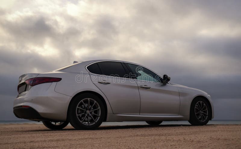 Alfa Romeo Giulia Stands on Golden Sand Against the Dramatic Sky ...
